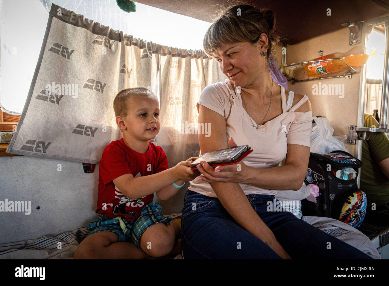 Mother Yulia (R) plays with her child Cyrille (L) on an evacuation ...