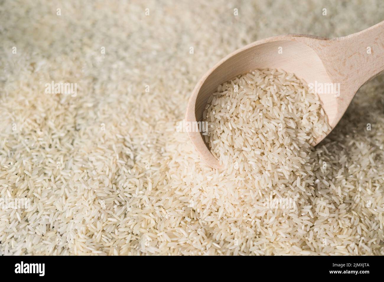 White rice wooden spoon backdrop Stock Photo - Alamy