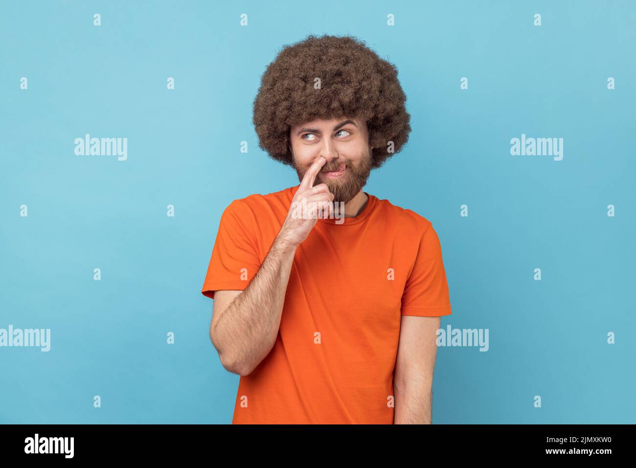 Portrait of childish man with Afro hairstyle wearing orange T-shirt ...