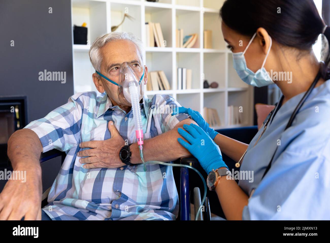Biracial female health worker helping caucasian senior man to use ...