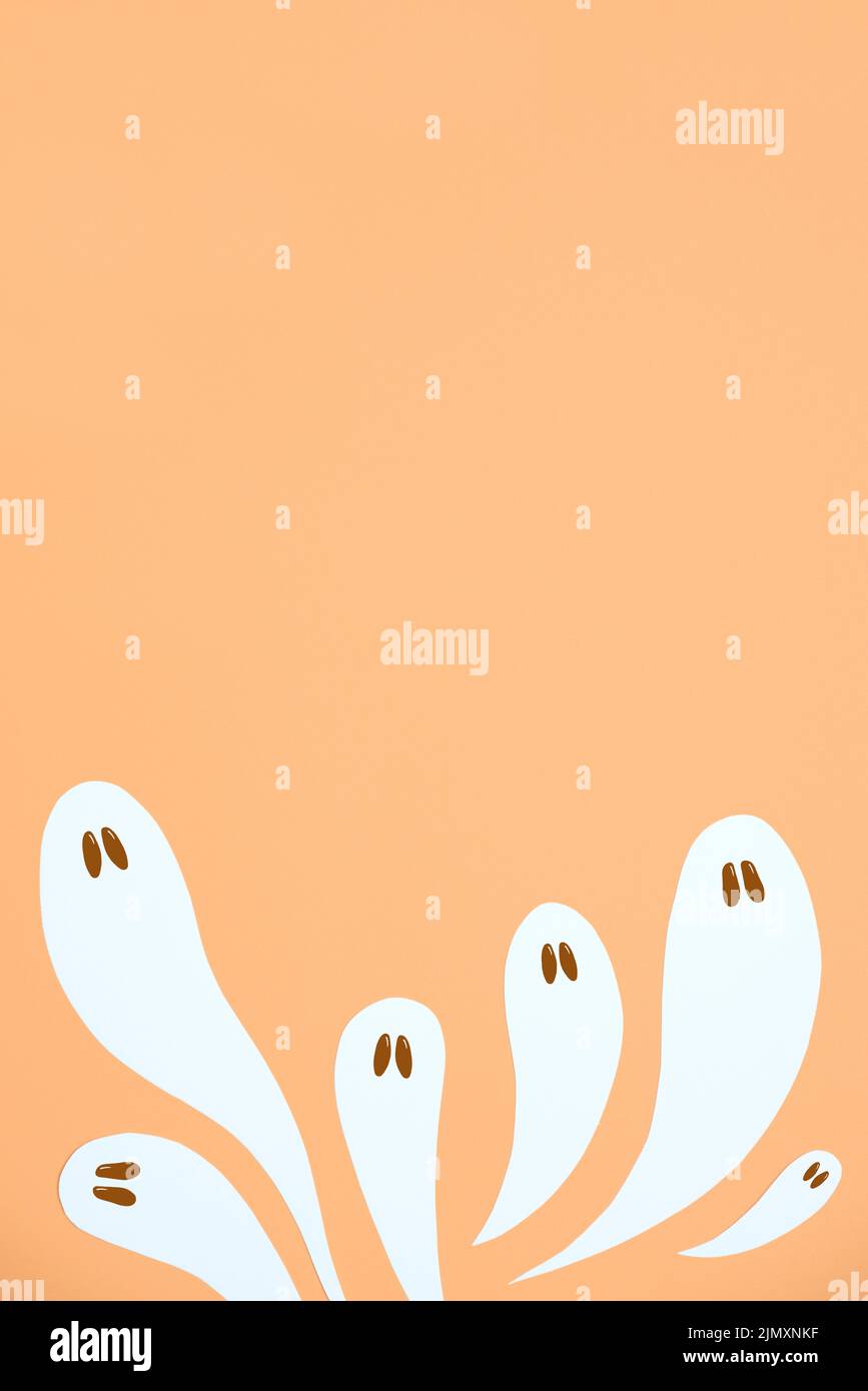 Halloween design, group of cute white ghosts flying on pastel orange ...