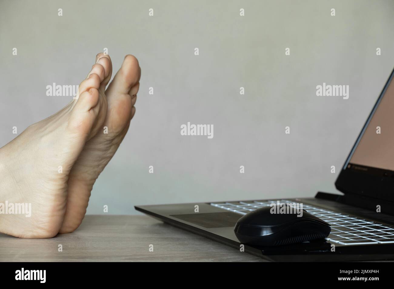 female legs on the desk near the laptop, rest at work, legs at the ...