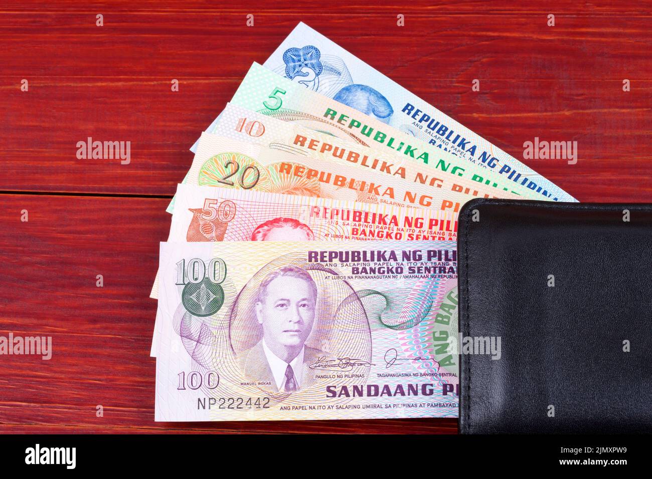 Old Philippine peso in the black wallet Stock Photo - Alamy