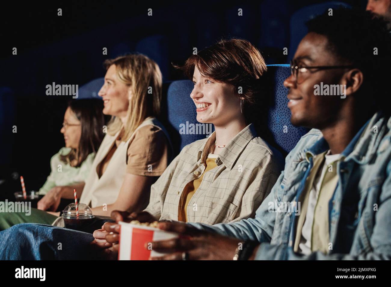 Group of cheerful multi-ethnic people spending time watching funny ...