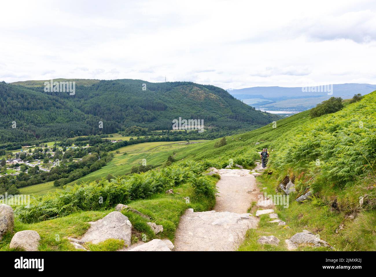 Hikers walking down the trail from Ben Nevis mountain range in Scotland ...