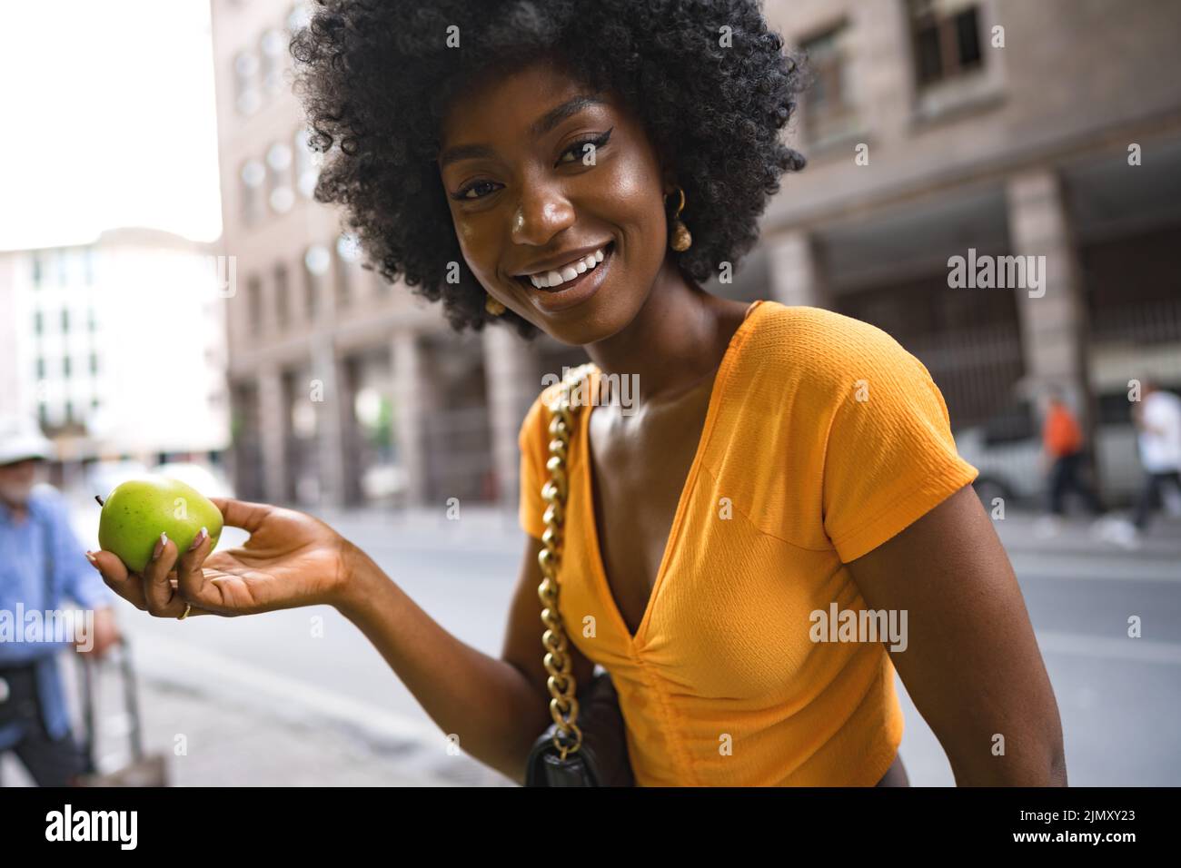Portrait of a young african american woman smiling standing at the city ...