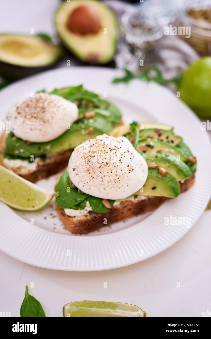 Freshly made poached egg and Avocado toasts on light grey background ...