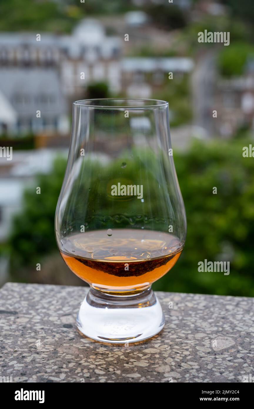 Dram of scotch whiskey with view on old houses on background, Edinburgh ...