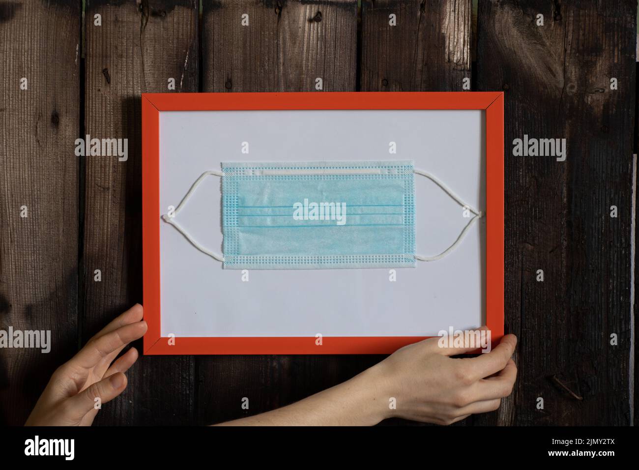 medical mask in a frame on an old wooden wall, a picture for the memory ...