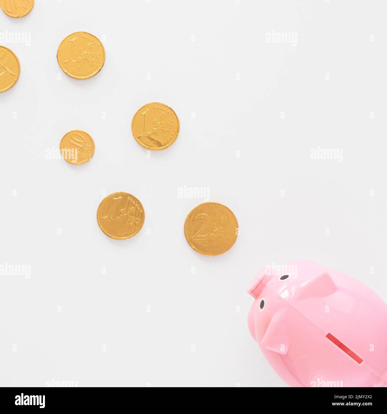 Piggy bank eating coins Stock Photo - Alamy