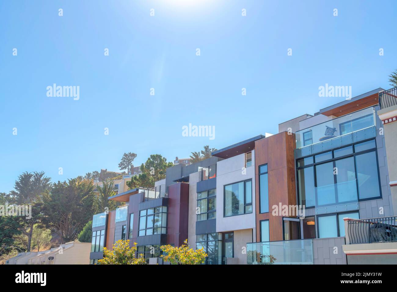 Modern townhouses with large glass windows and wood wall cladding in ...