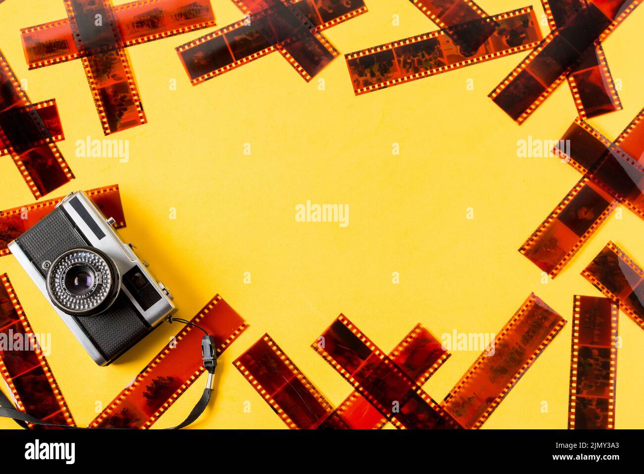 Old fashioned camera with negatives yellow background Stock Photo - Alamy