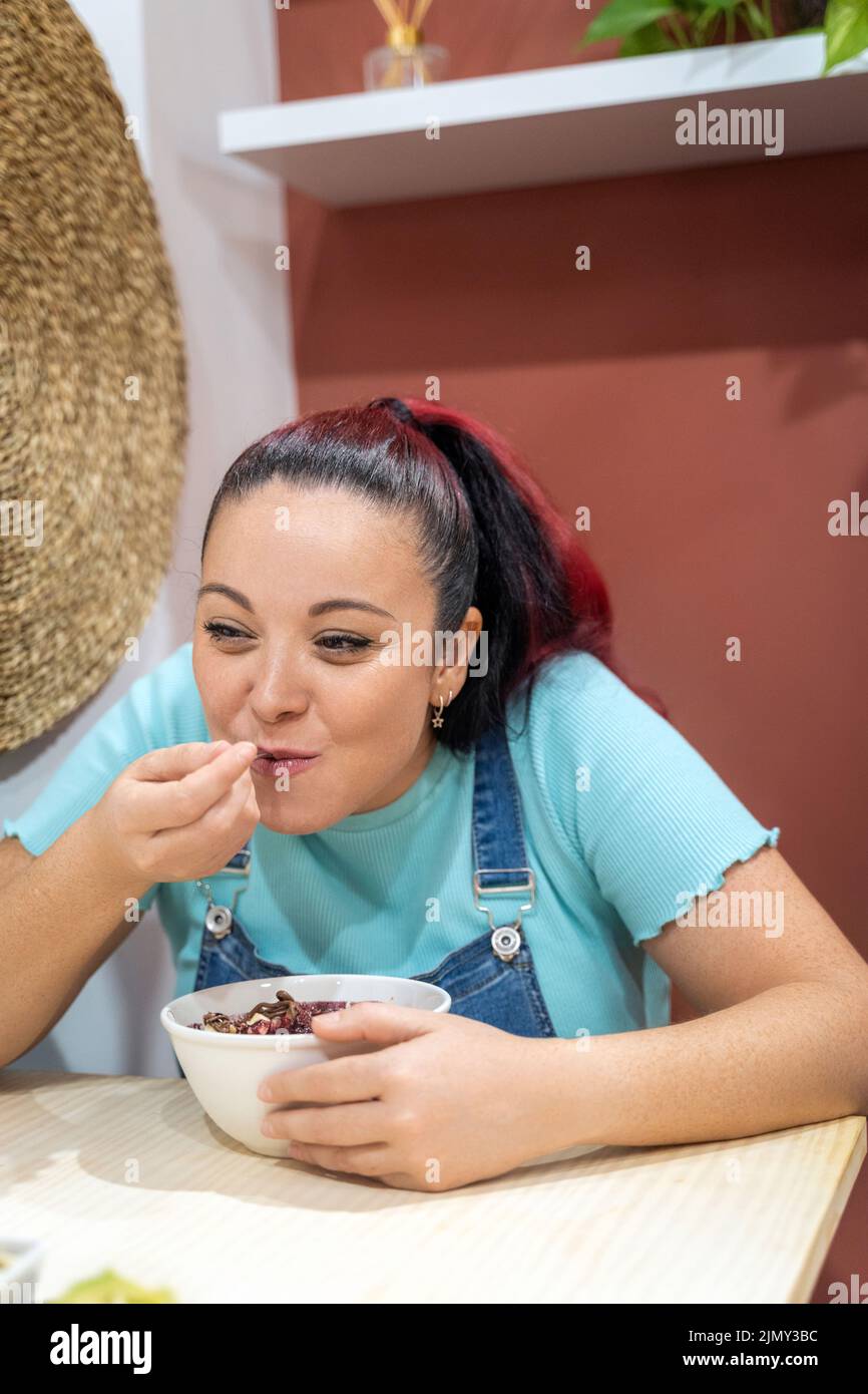 Woman enjoying eating a healthy bowl in a cafe. Healthy eating concept ...