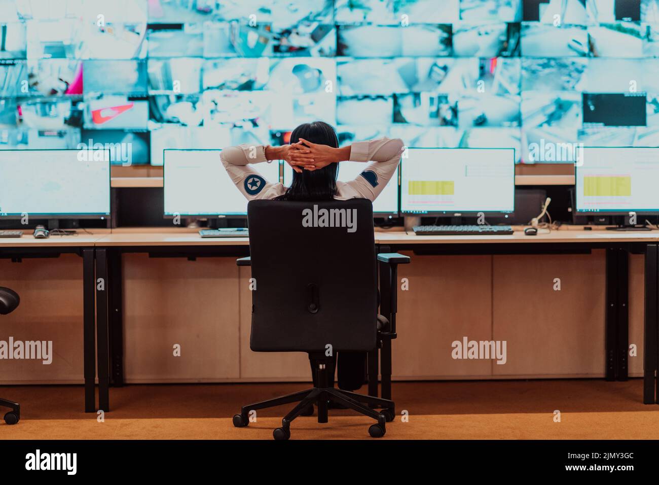 Female security operator working in a data system control room offices ...