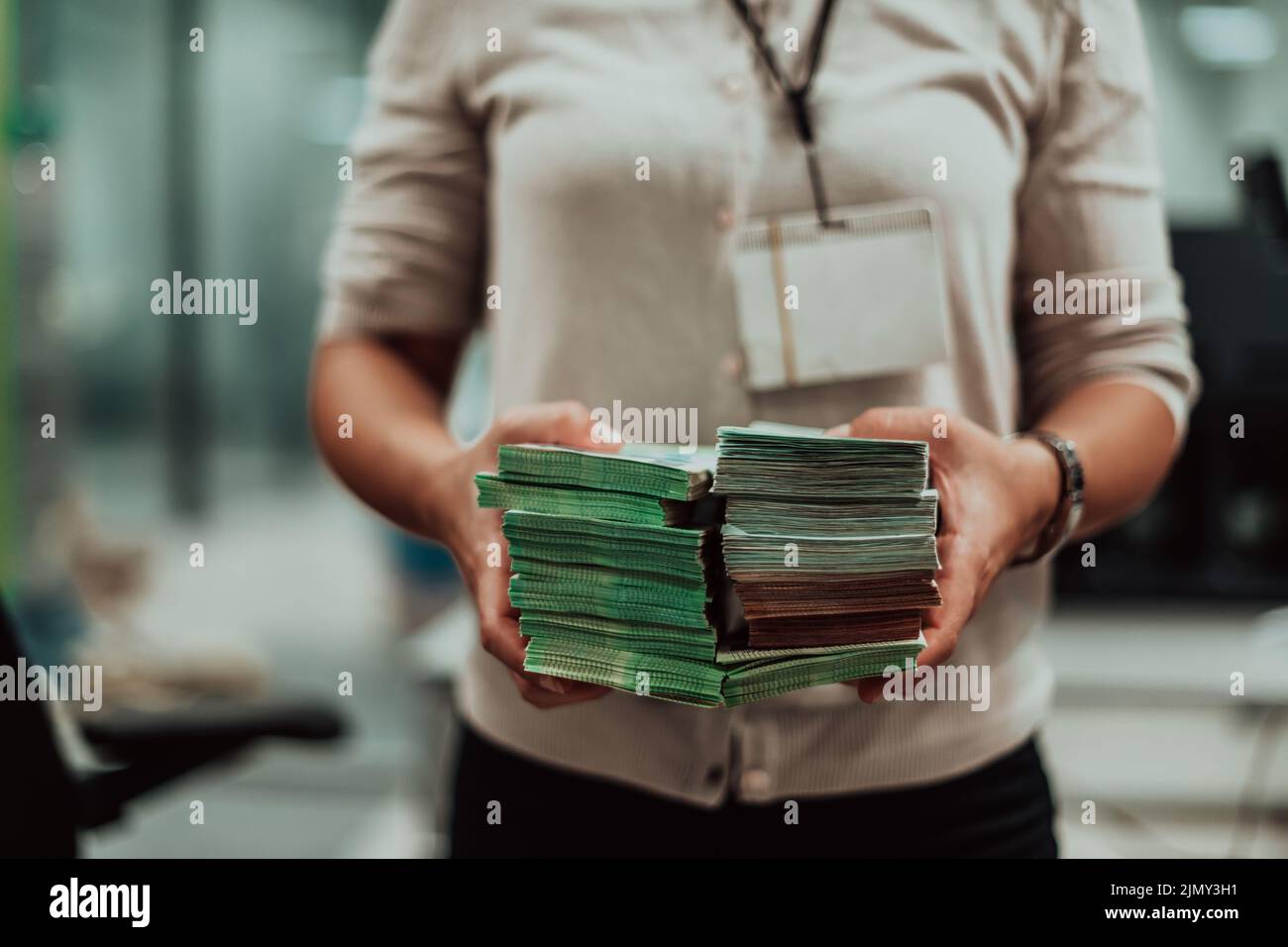 Bank employees holding a pile of paper banknotes while sorting and ...