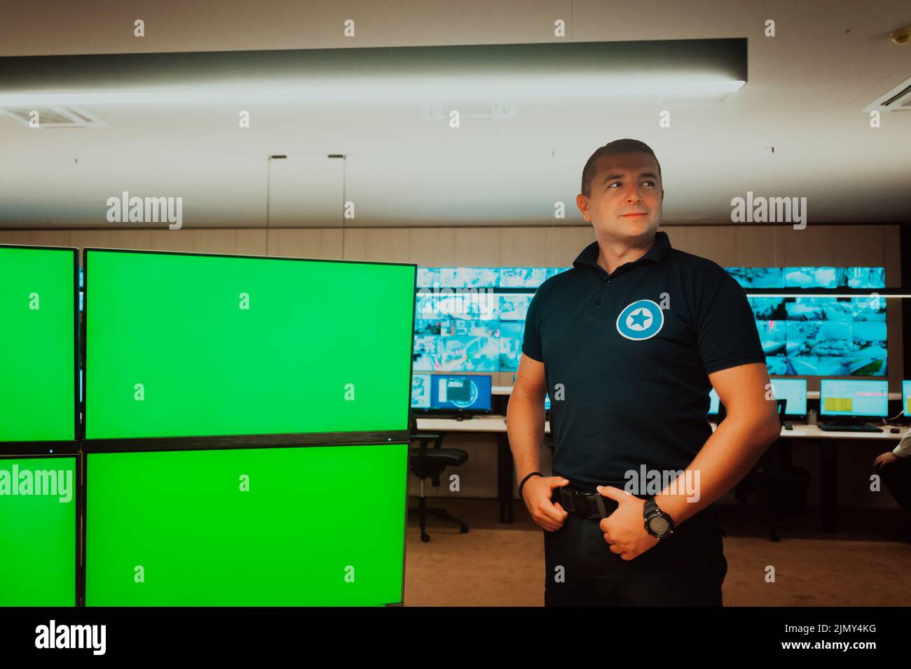 Male security operator working in a data system control room offices ...