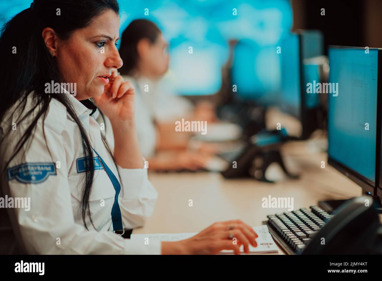 Female security guard operator talking on the phone while working at ...