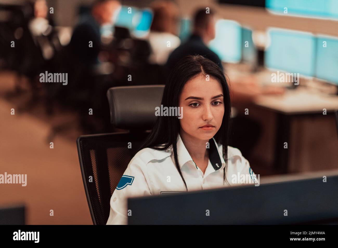Female security operator working in a data system control room offices ...