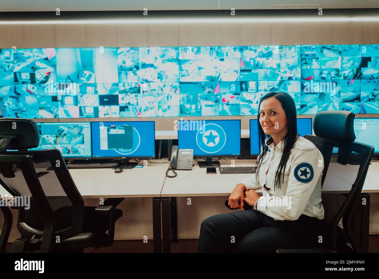 Female security operator working in a data system control room offices ...