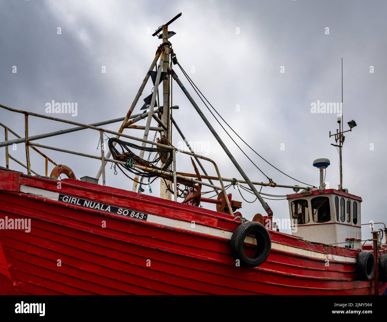 Colorful red fishing boat trawler in the sheltered port and harbor of ...