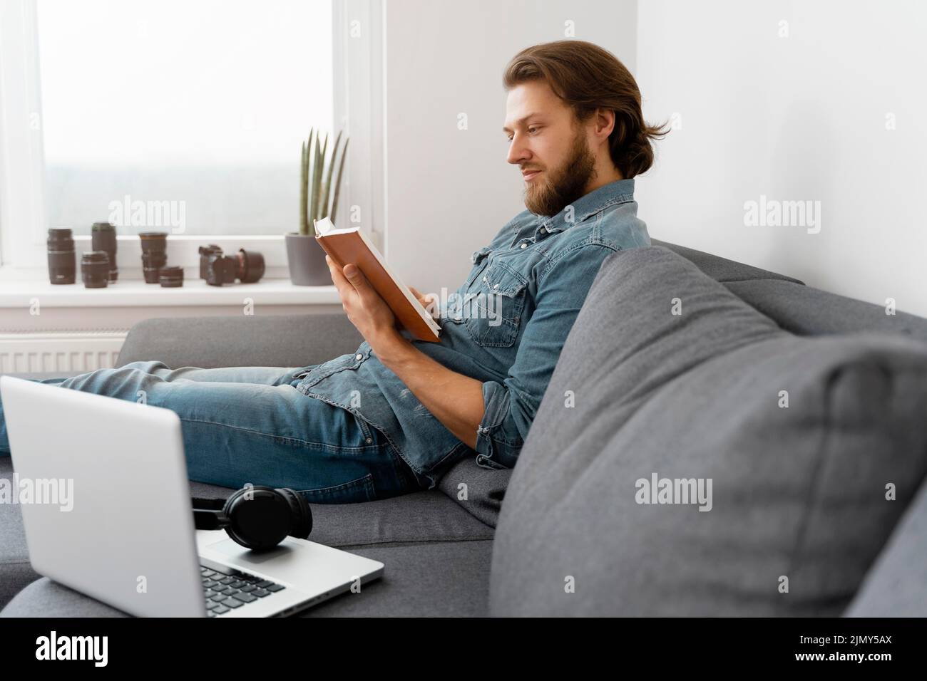 Medium shot man reading book Stock Photo - Alamy