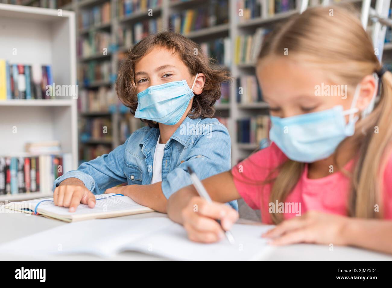 Kids doing homework while wearing medical masks Stock Photo - Alamy