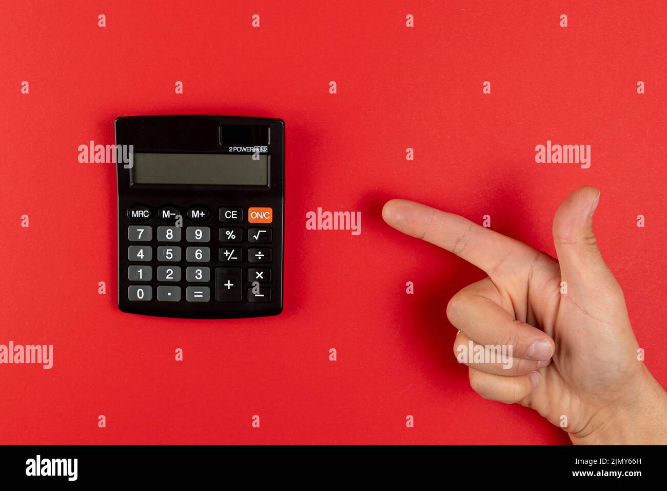 Hand pointing mini calculator Stock Photo - Alamy
