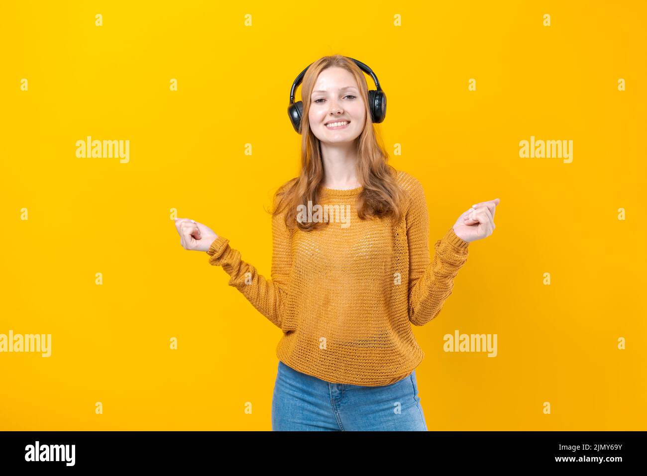 Woman dancing to music while listening to MP3 player with wired ...