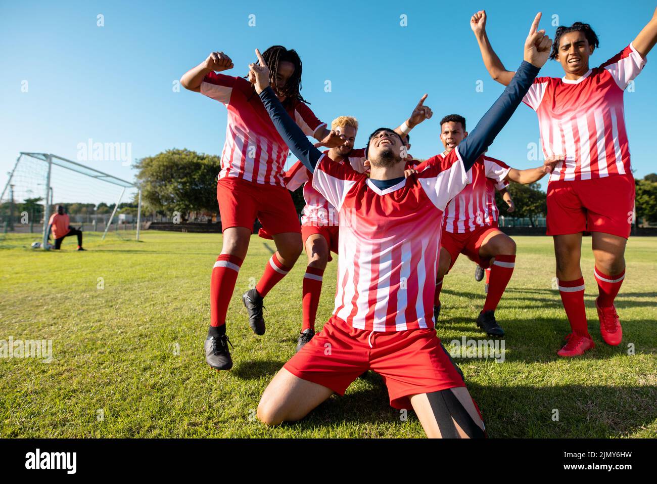 Multiracial team with arms raised running towards cheerful player ...