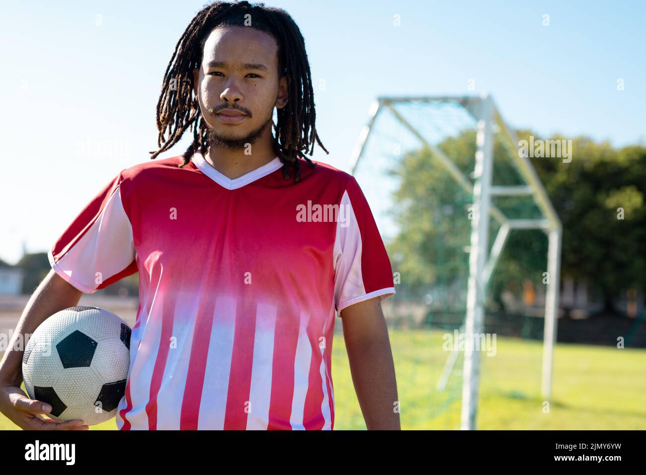 Serious biracial male player with dreadlocks wearing red jersey with ...