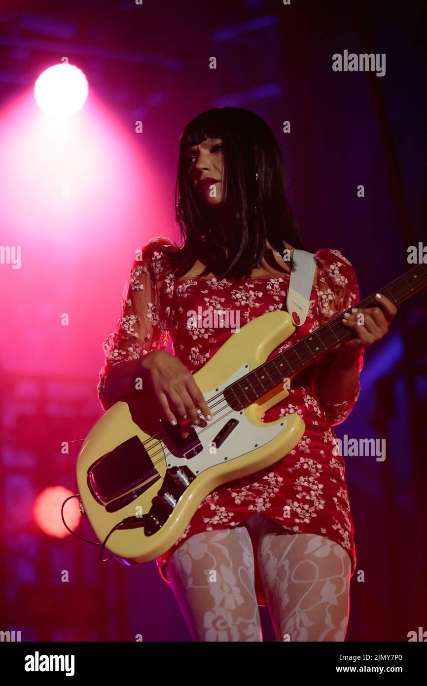Bassist Laura Lee of Khruangbin on stage wearing a red floral mini ...