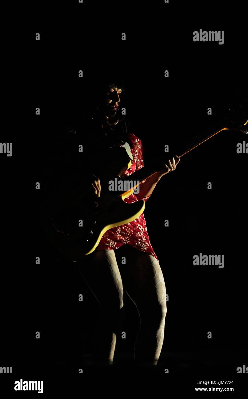 Bassist Laura Lee of Khruangbin on stage wearing a red floral mini ...