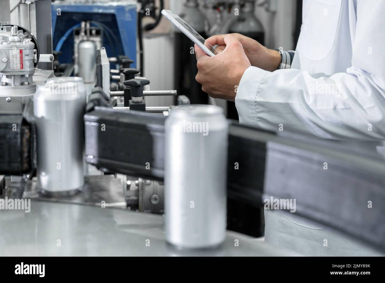 Factory worker inspecting production line on beverage factory with ...