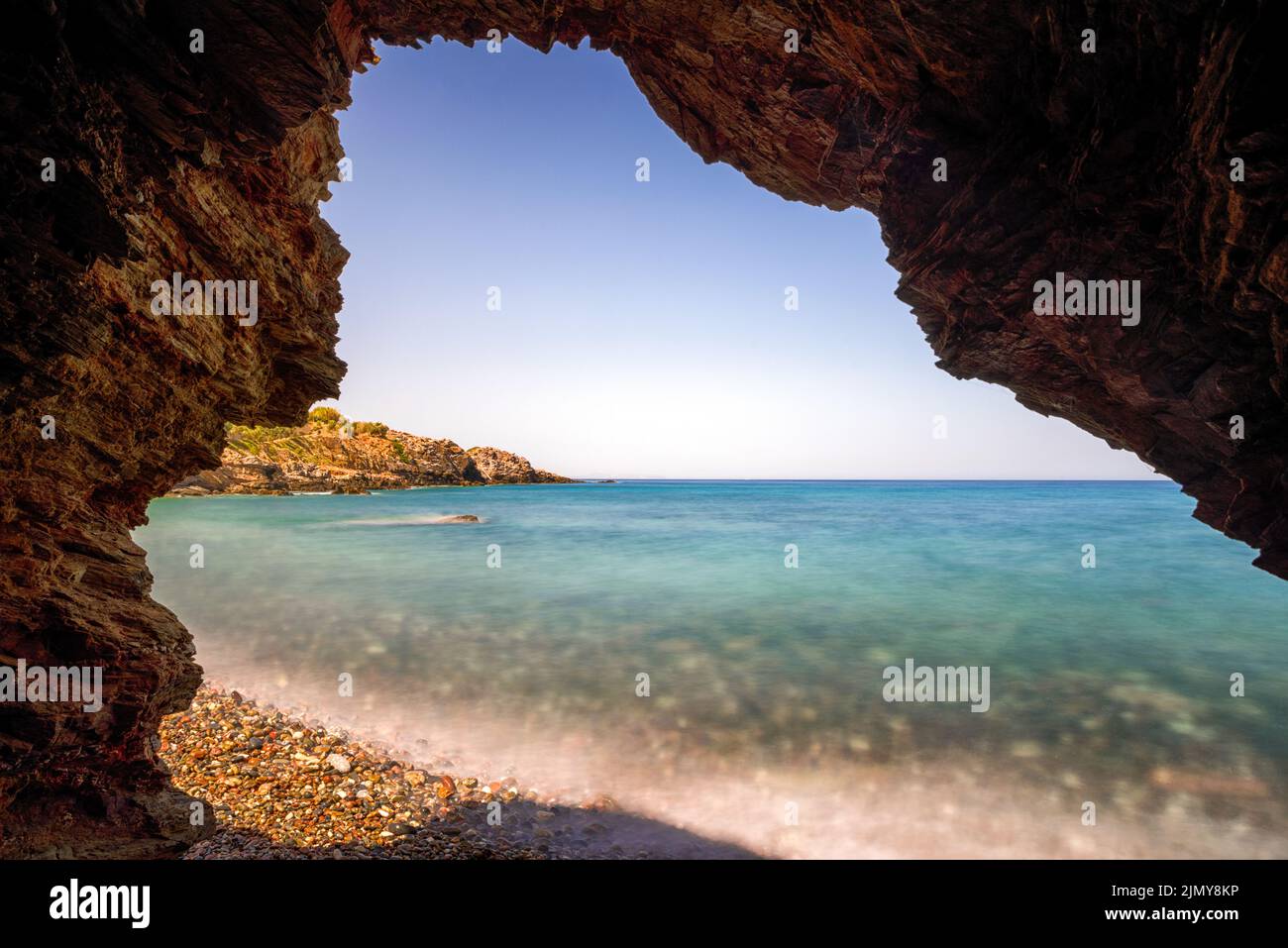 pebble beach and reef with long exposure water in sea. Crete island ...