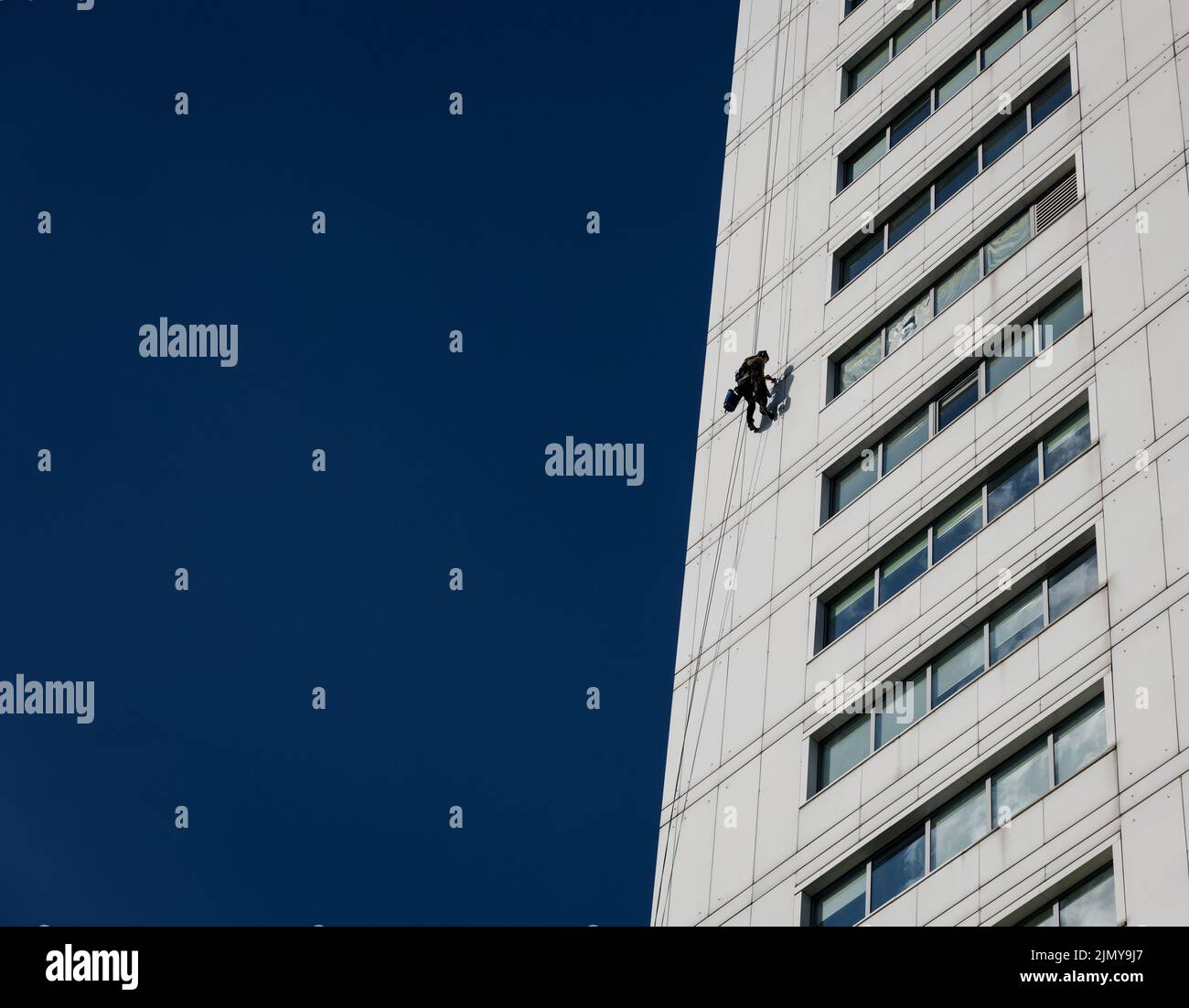 Industrial climber in helmet and uniform on height. Risky job. Extreme ...