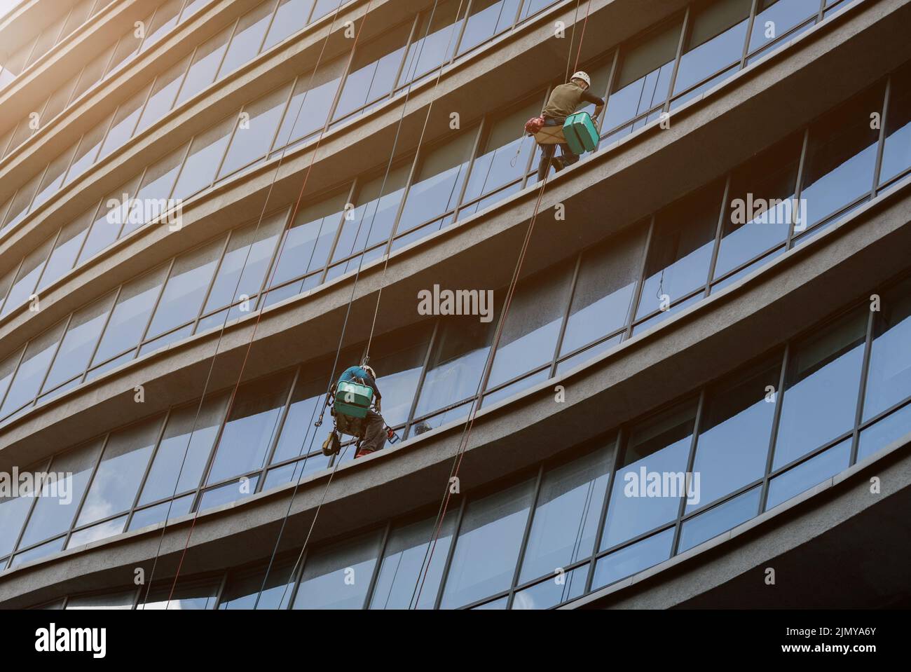 workers wash the facade of the building. Washer washing the windows ...