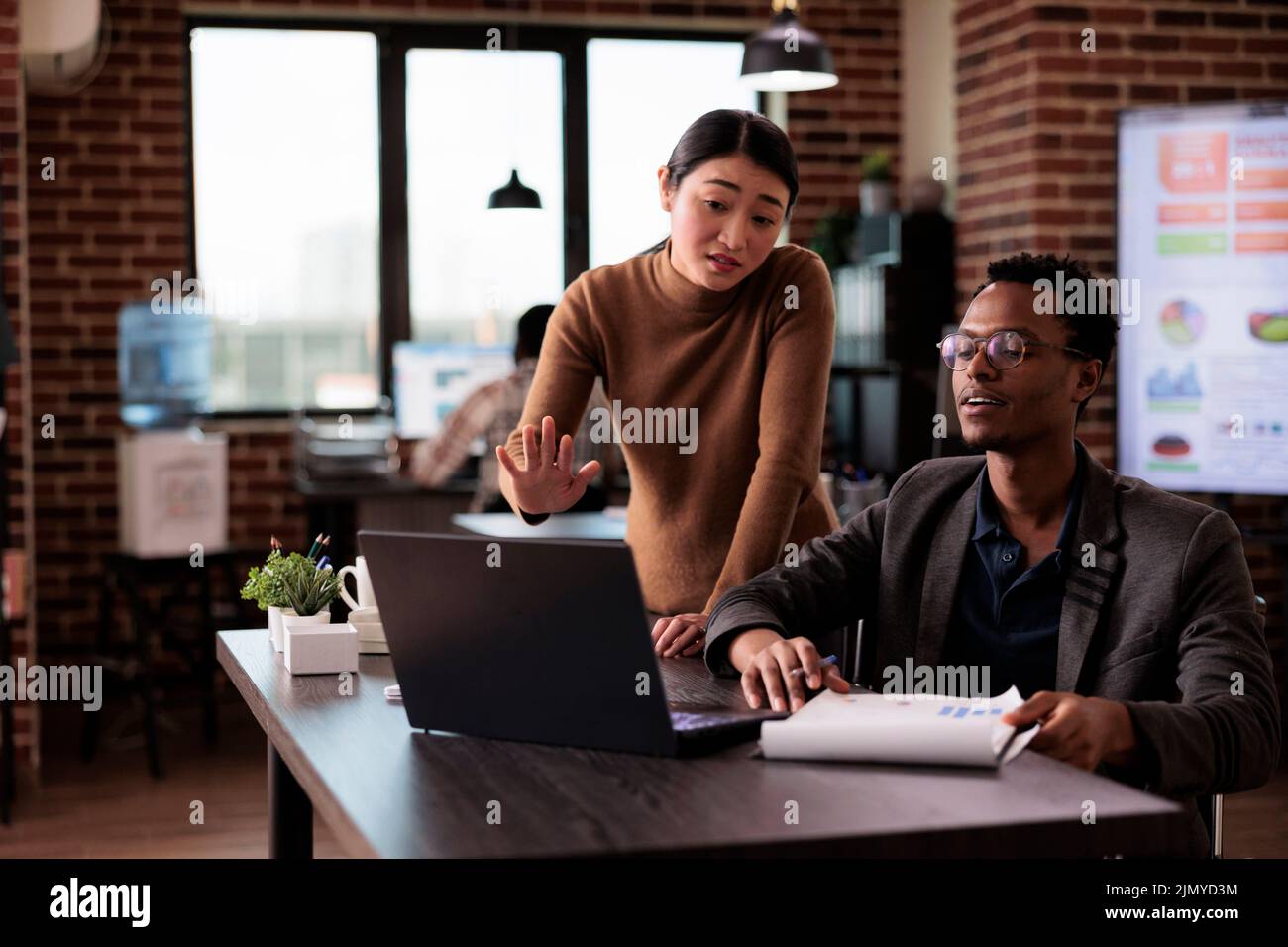 Multiethnic team of partners working on laptop in disability friendly ...