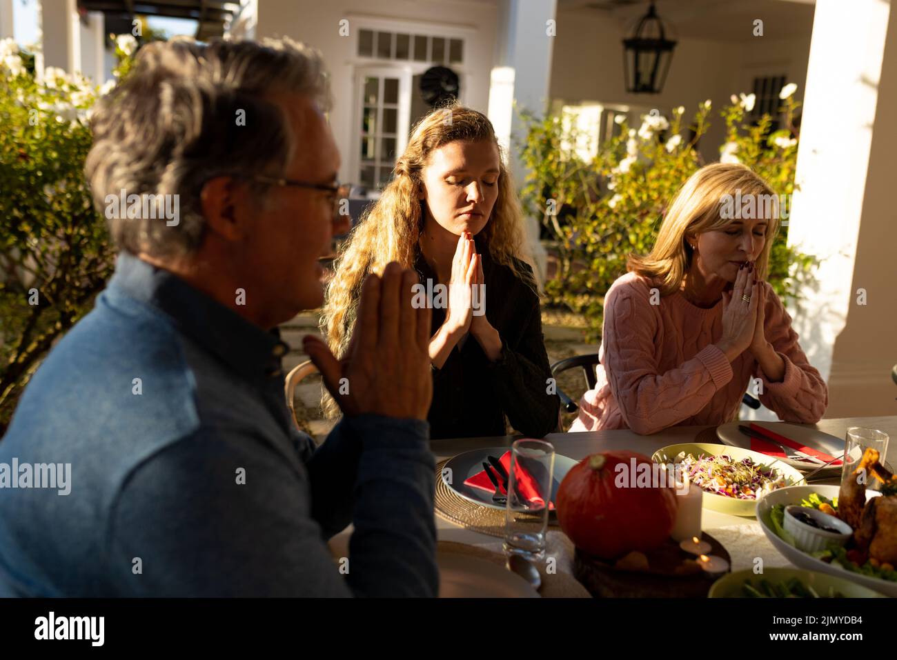 Image of multi generation caucasian family praying before outdoor ...