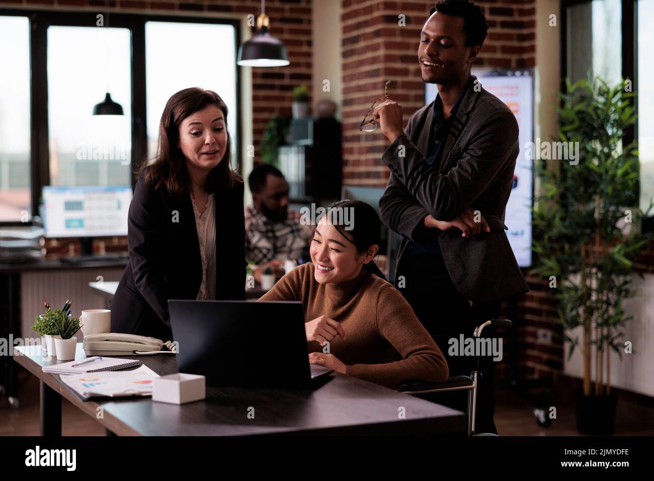 Diverse team of colleagues and woman with disability brainstorming ...