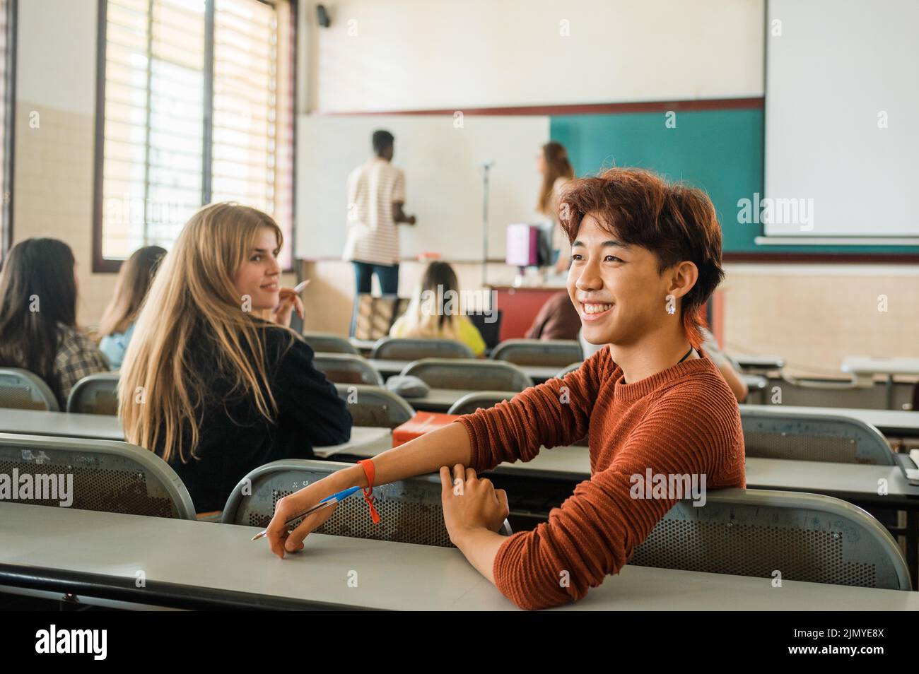 Cheerful Asian student speaking during lesson Stock Photo - Alamy