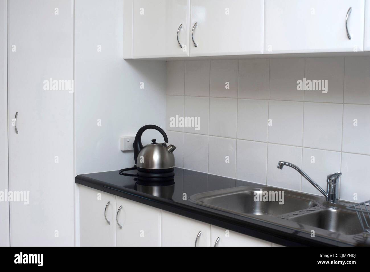 Kitchen worktop with kettle and stainless steel double sink and white ...
