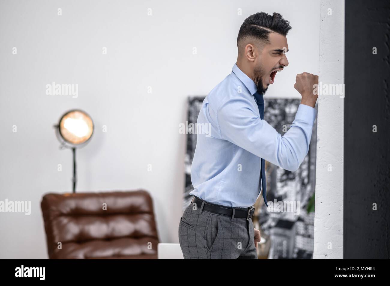 Angry man touching wall with his fist Stock Photo - Alamy