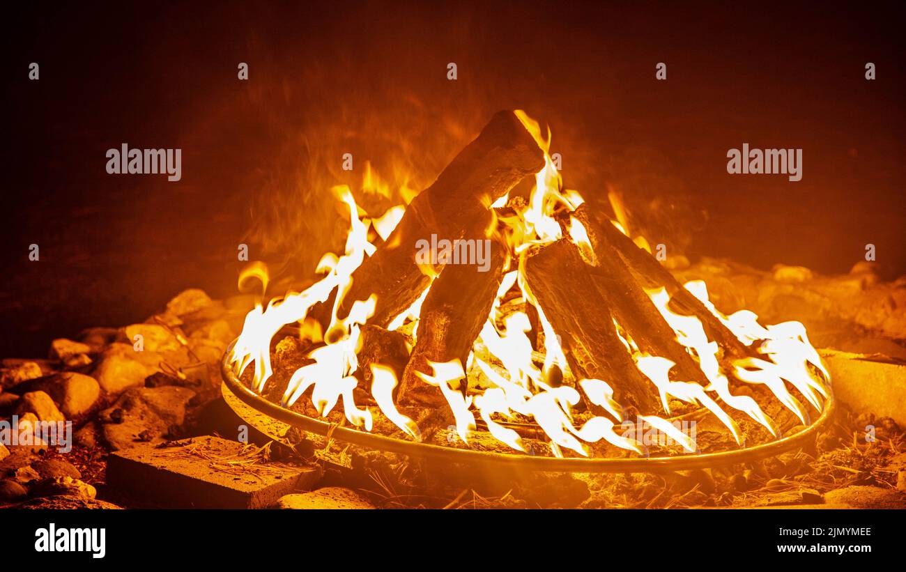 The close-up view of the burning woods in the fire flames on the plate ...