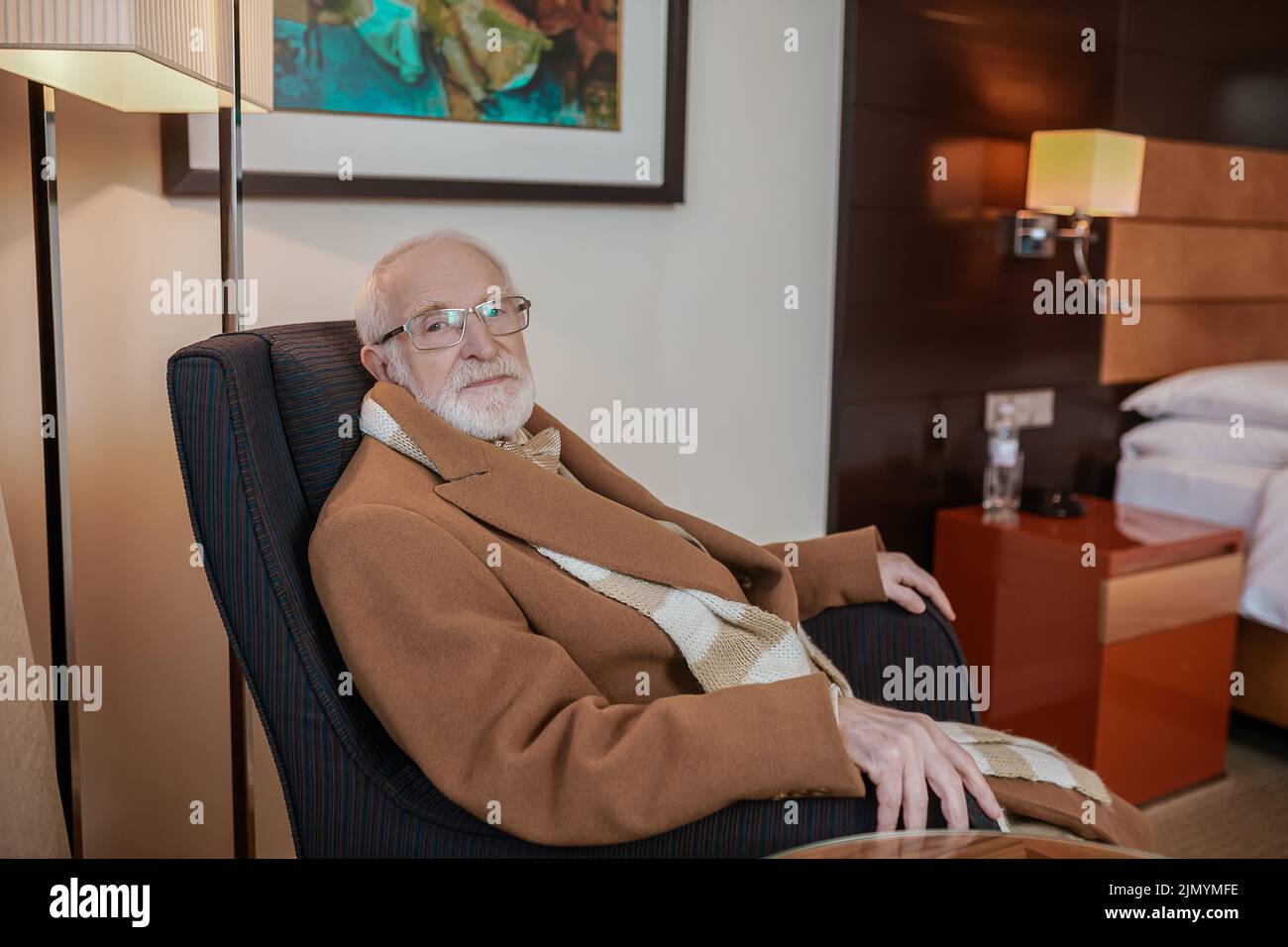 Bearded gentleman sitting in an arcmchair in a hotel Stock Photo - Alamy