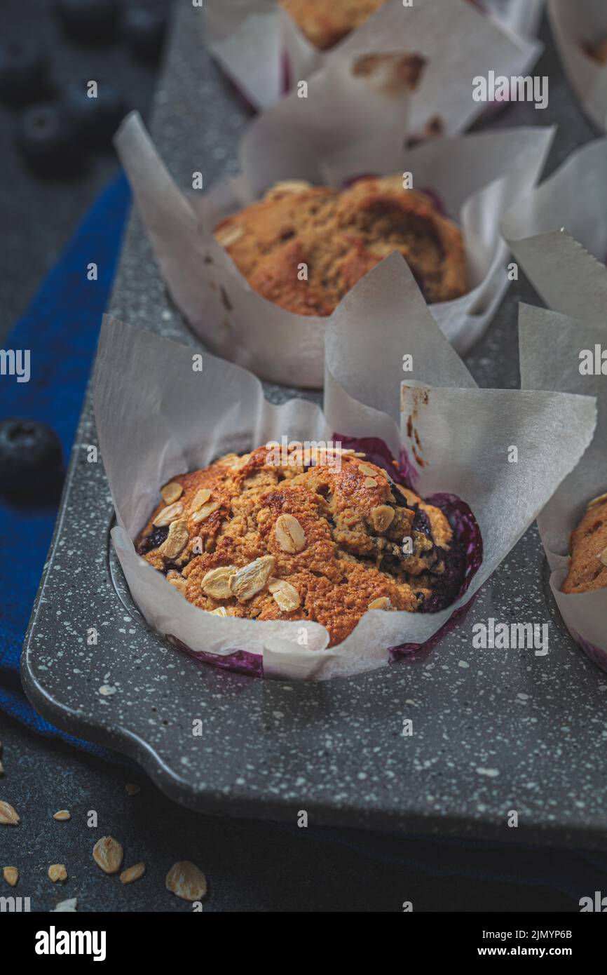 Vegan oatmeal, banana, blueberry muffins on a blue background, close-up ...