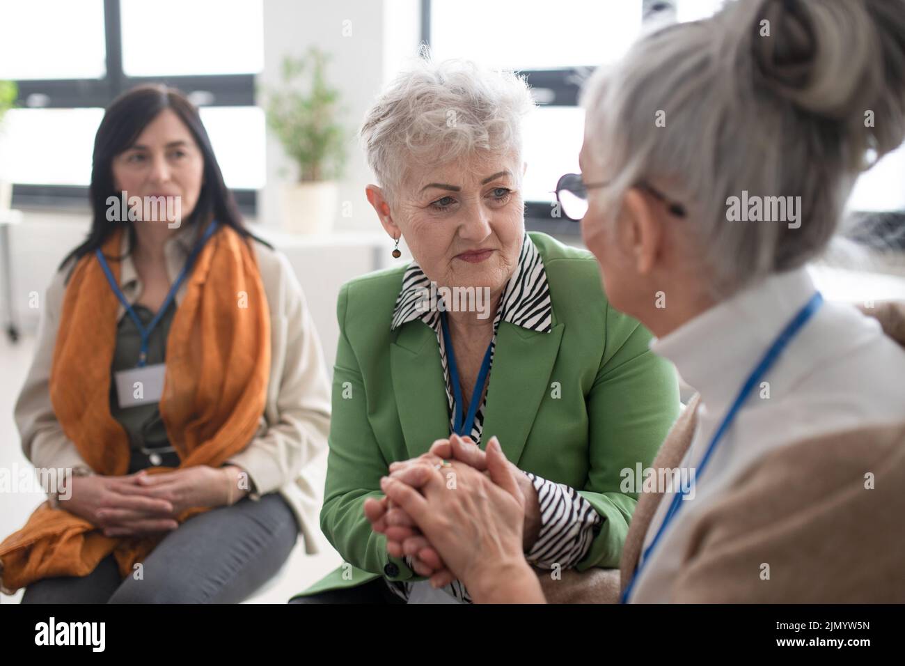 Group of senior people sitting in circle during therapy session ...