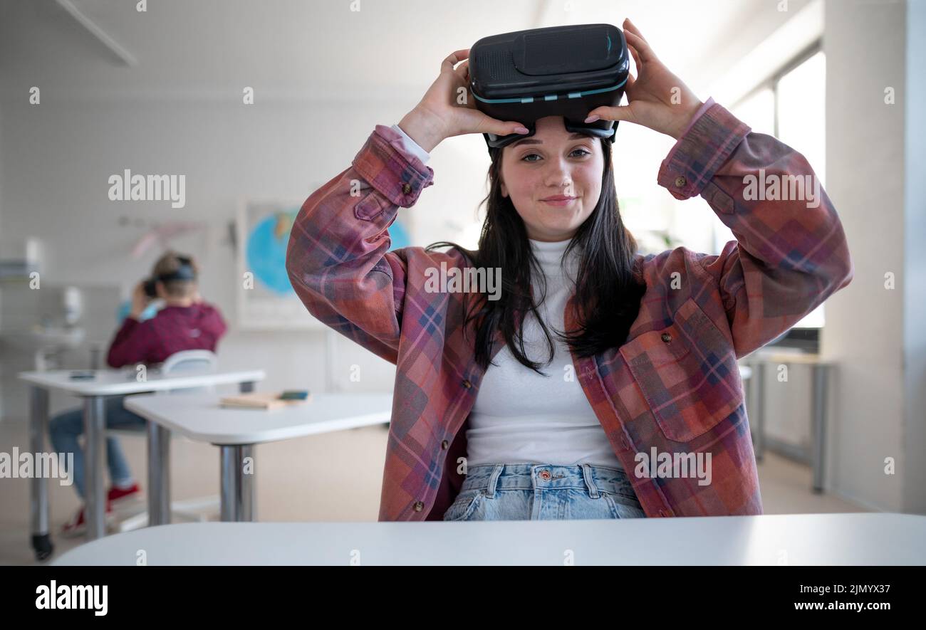 Happy student wearing virtual reality goggles at school in computer ...