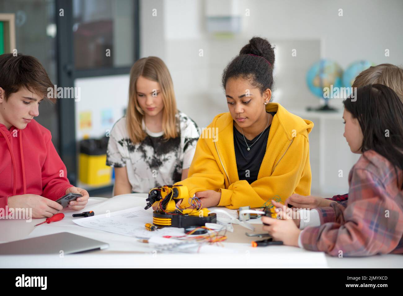 Group of students building and programming electric toys and robots at ...