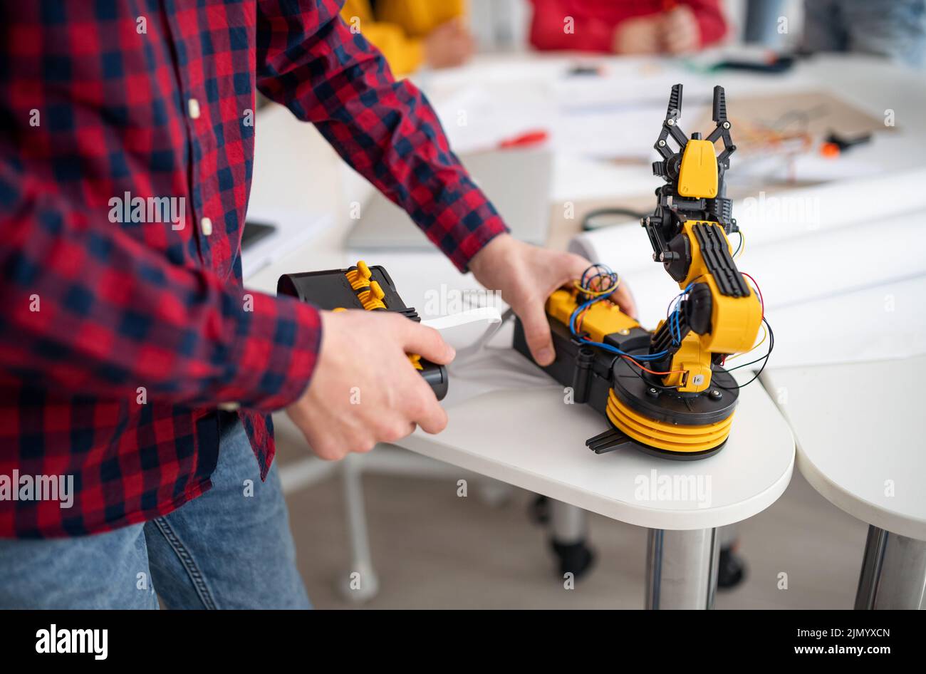 College student engineering his builded robotic toy in science robotics ...