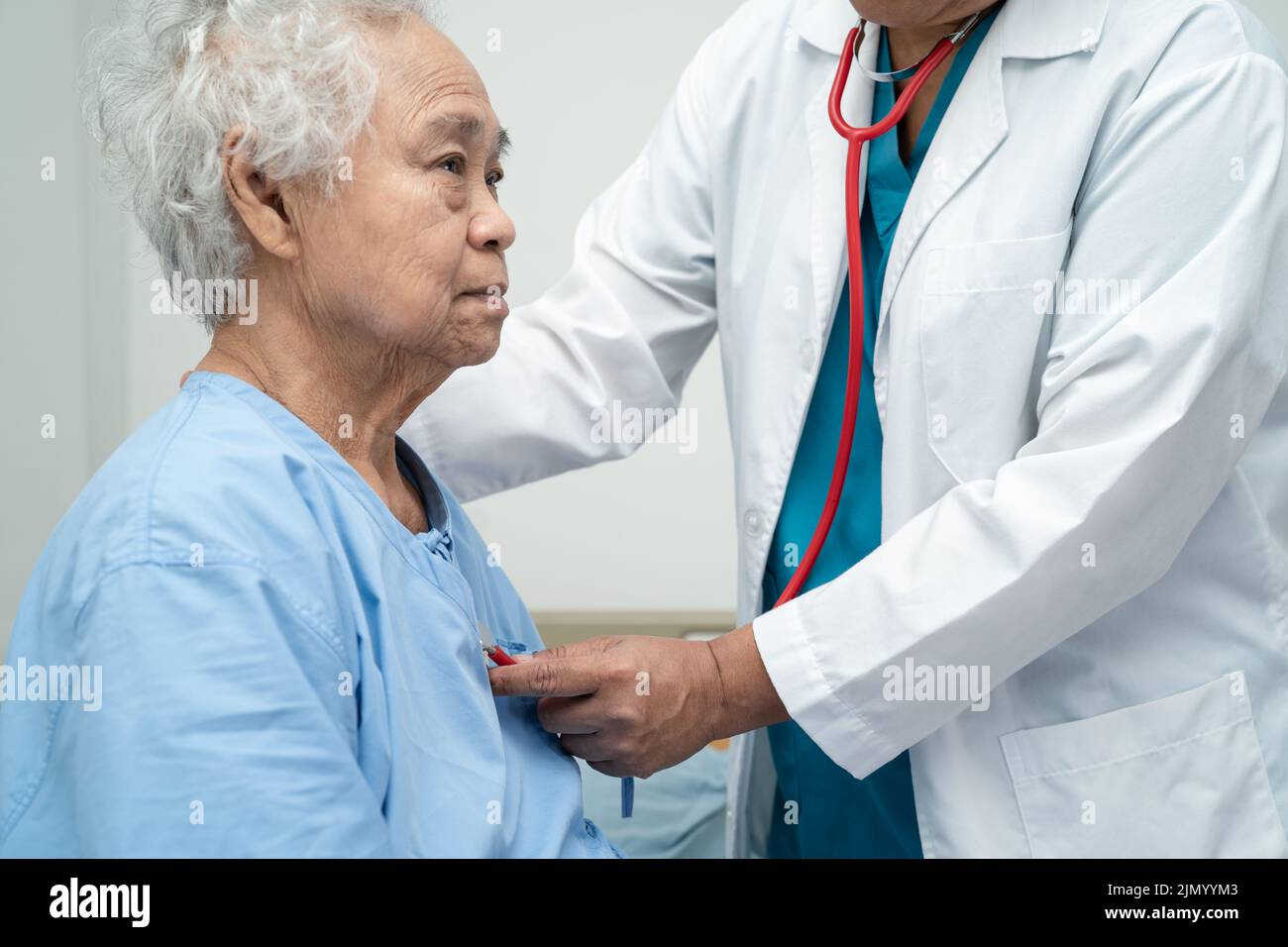 Doctor with stethoscope checking senior or elderly old lady woman ...